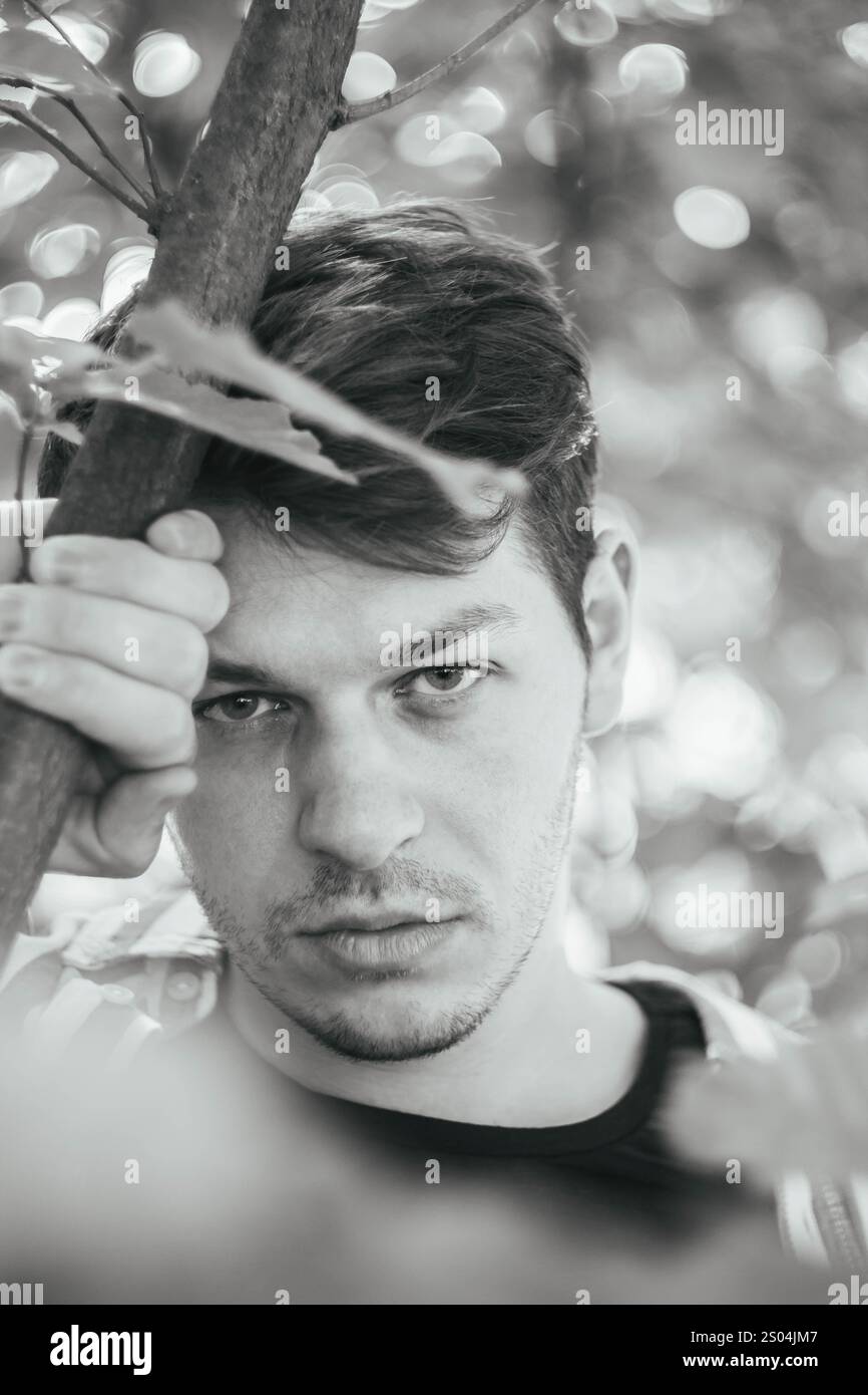 A striking black and white close-up of a man's face against a forest ...