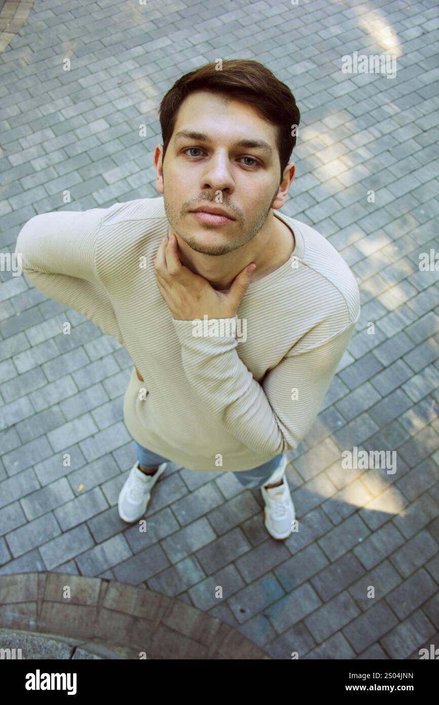 From a high vantage point, a man stands on a cobblestone street. The ...