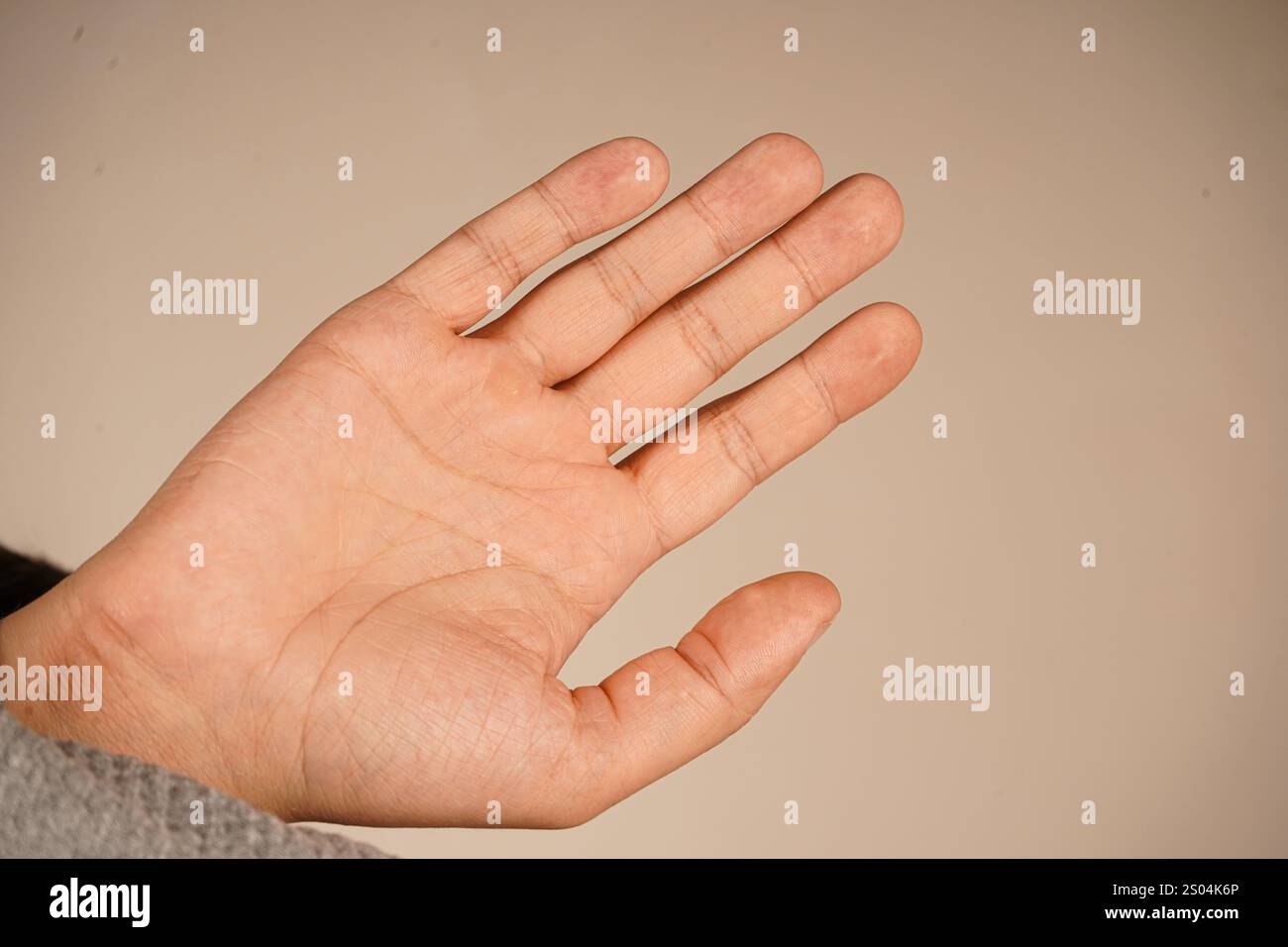 An open palm is extended forward, creating a gesture that can signify ...