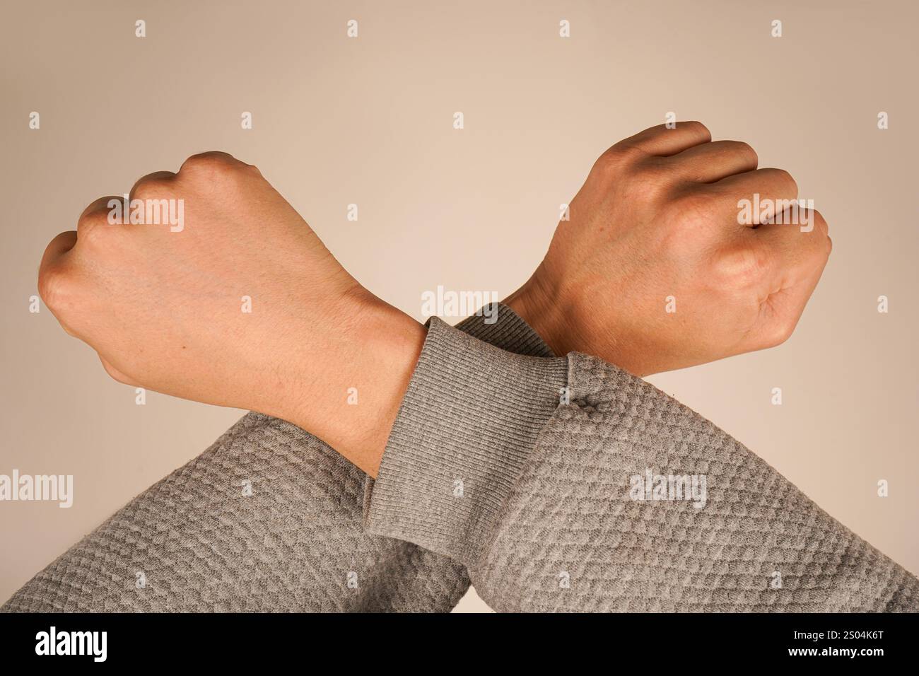 The crossed arms are clenched into fists. This posture radiates ...
