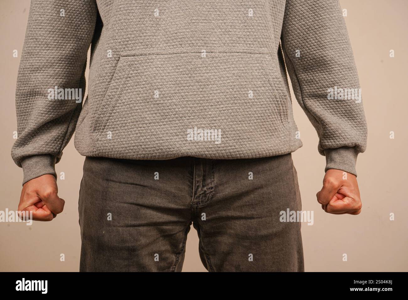 A man clenches his hand tightly into a fist, all the tendons and veins ...