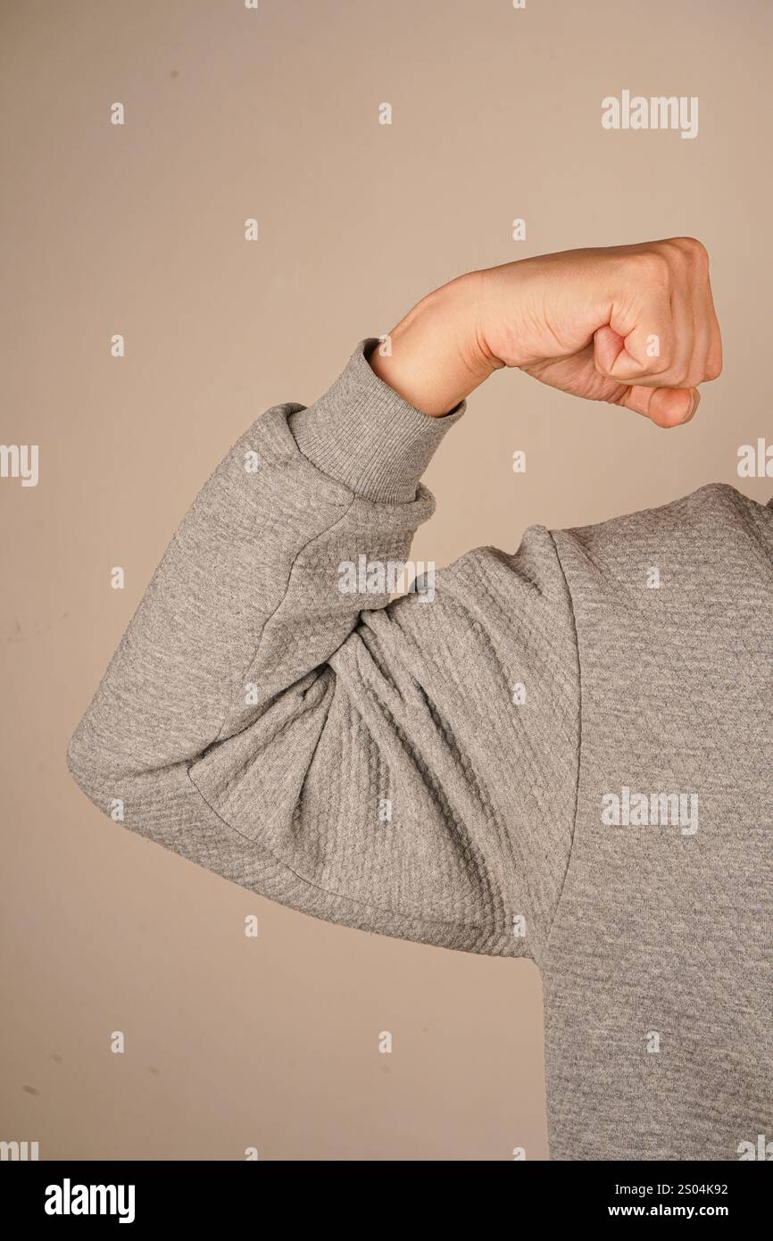 The clean background ensures the focus remains on the gesture. A flexed ...