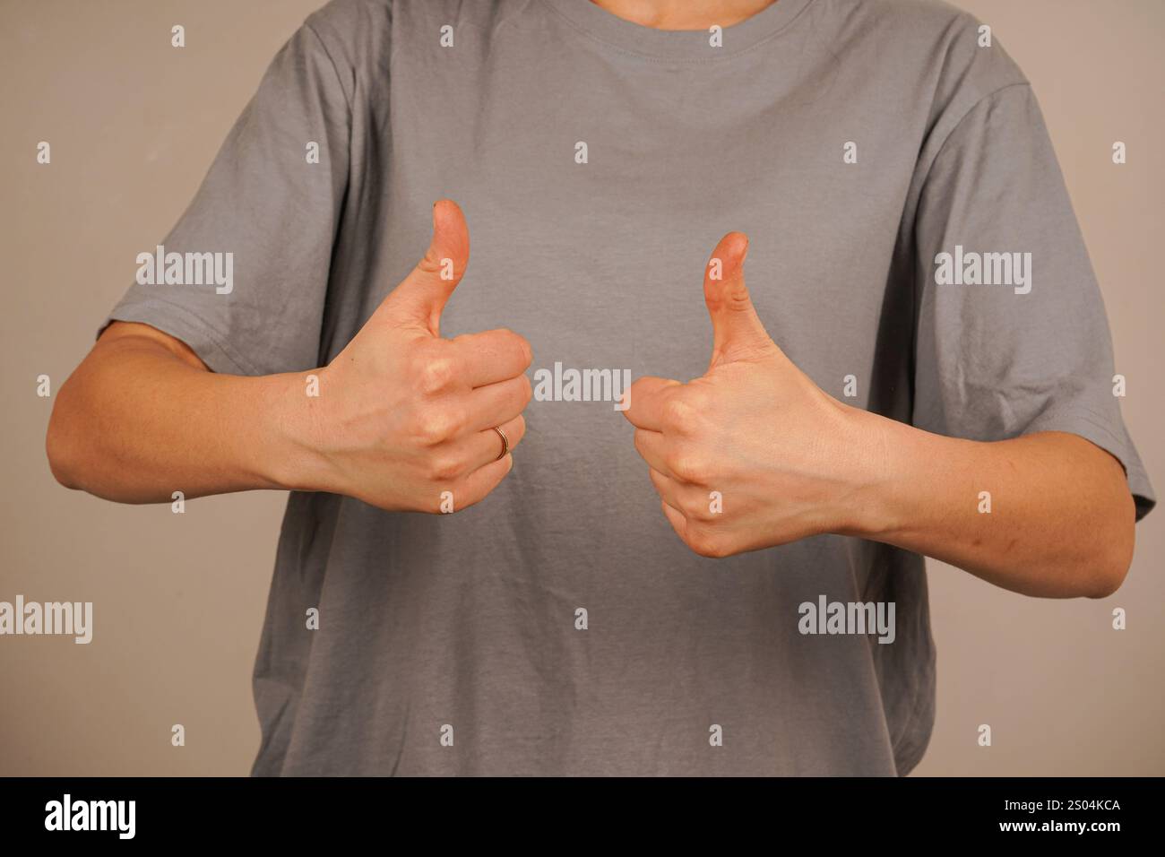 Hands showing a double thumbs-up signal optimism and encouragement. The ...