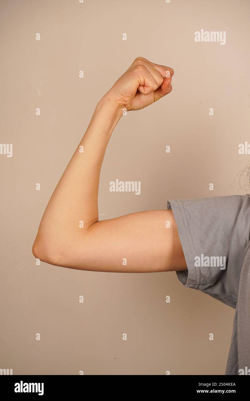 The powerful gesture conveys confidence and determination. A flexed arm with a clenched fist ...