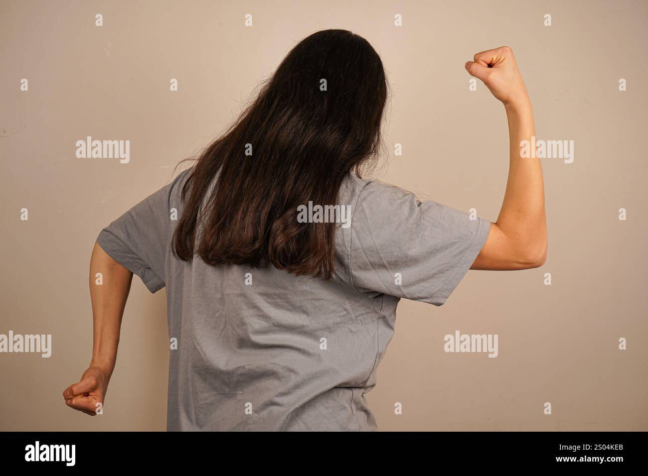 A girl demonstrates the power of her arms.The powerful gesture conveys ...