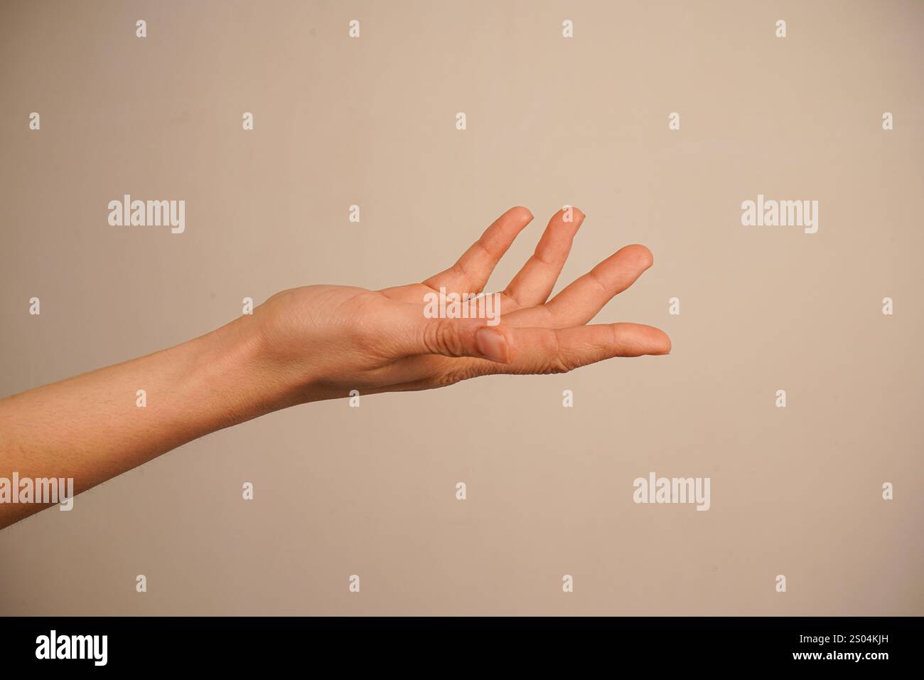 On a light background of the wall, the hand is up to the elbow. The ...