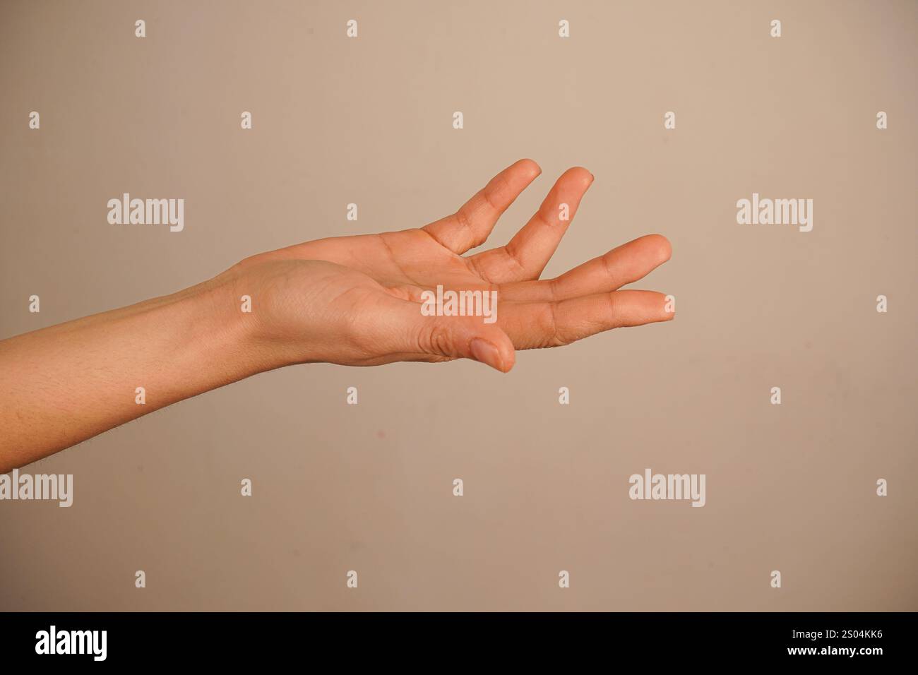 On a light background of the wall, the hand is up to the elbow. The ...