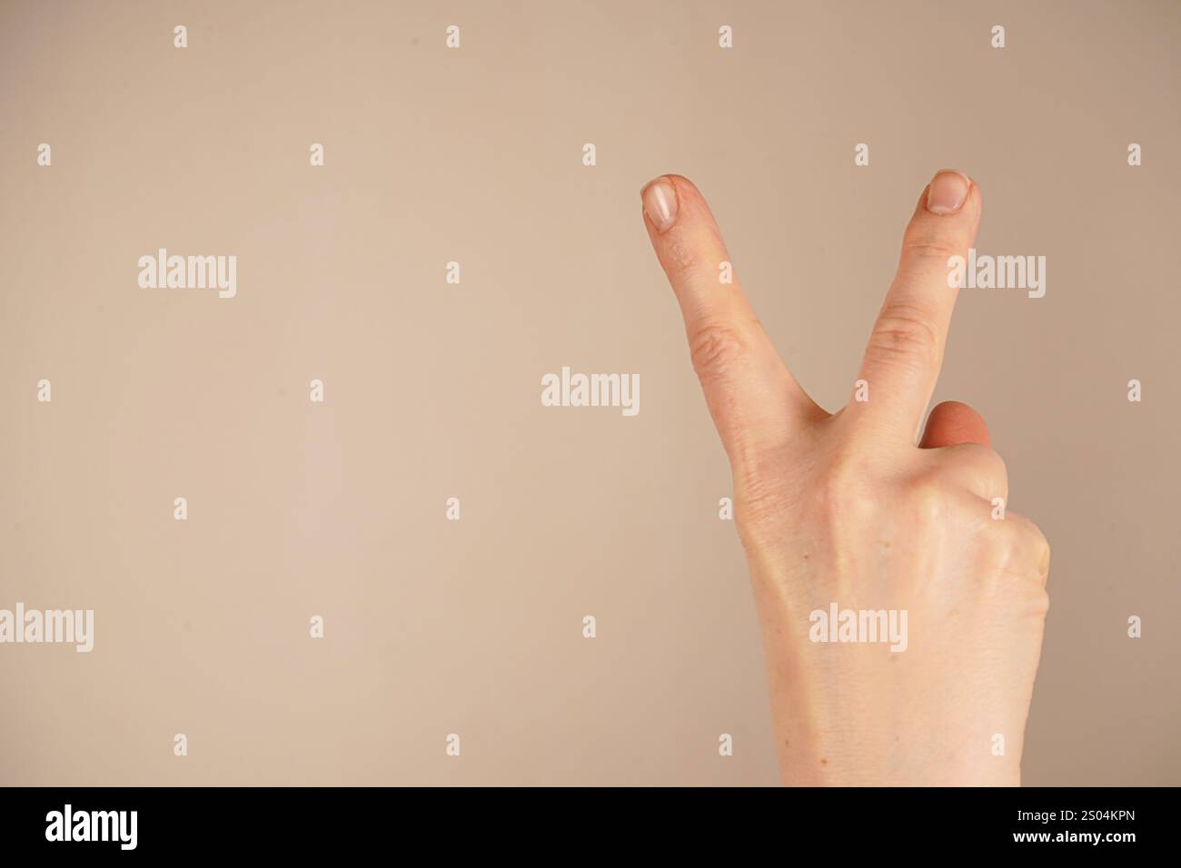 A hand forms the peace symbol with two fingers raised and apart. The ...