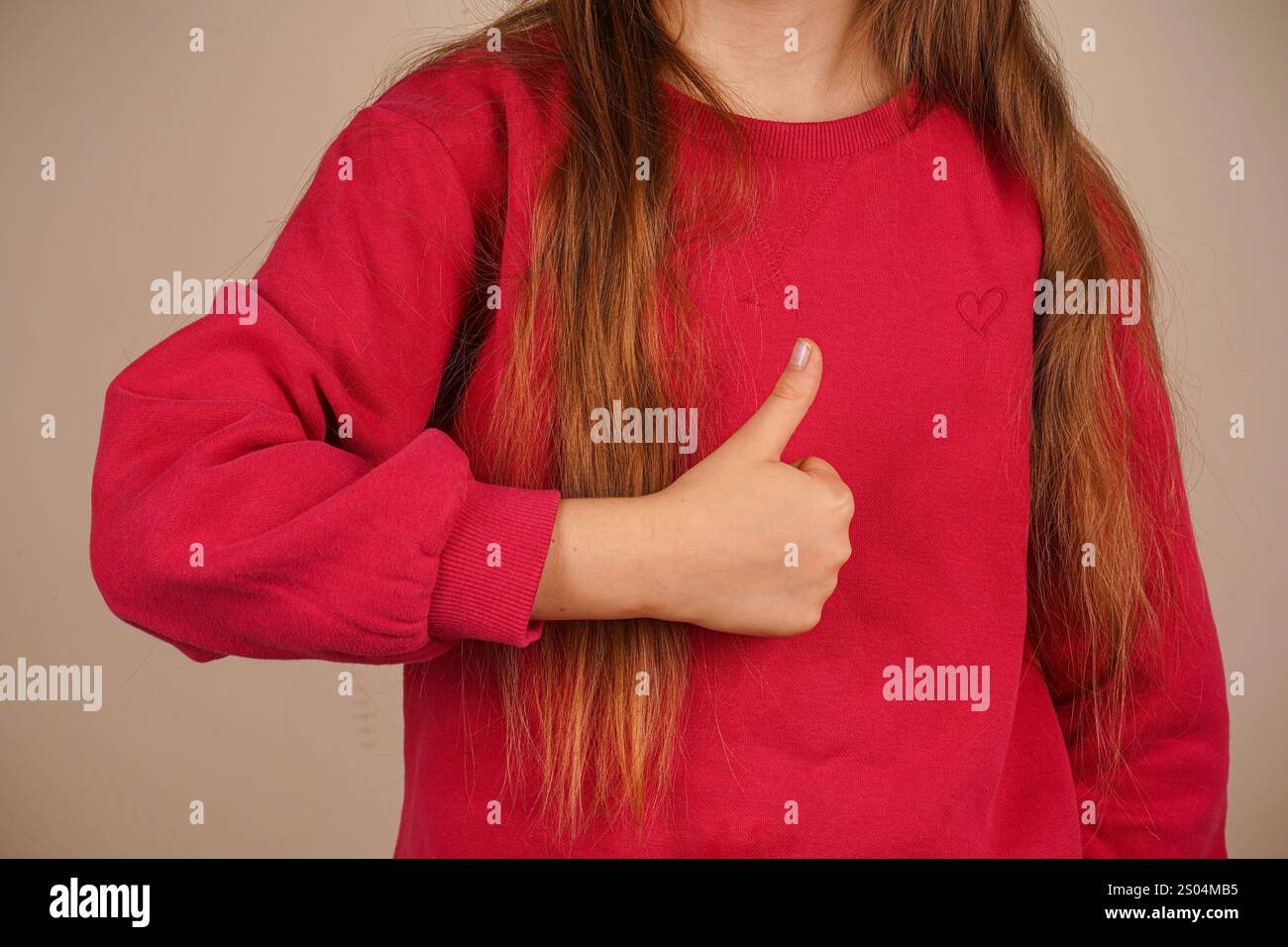 The hand shows a like. A thumbs up sign is displayed on a plain, bright ...