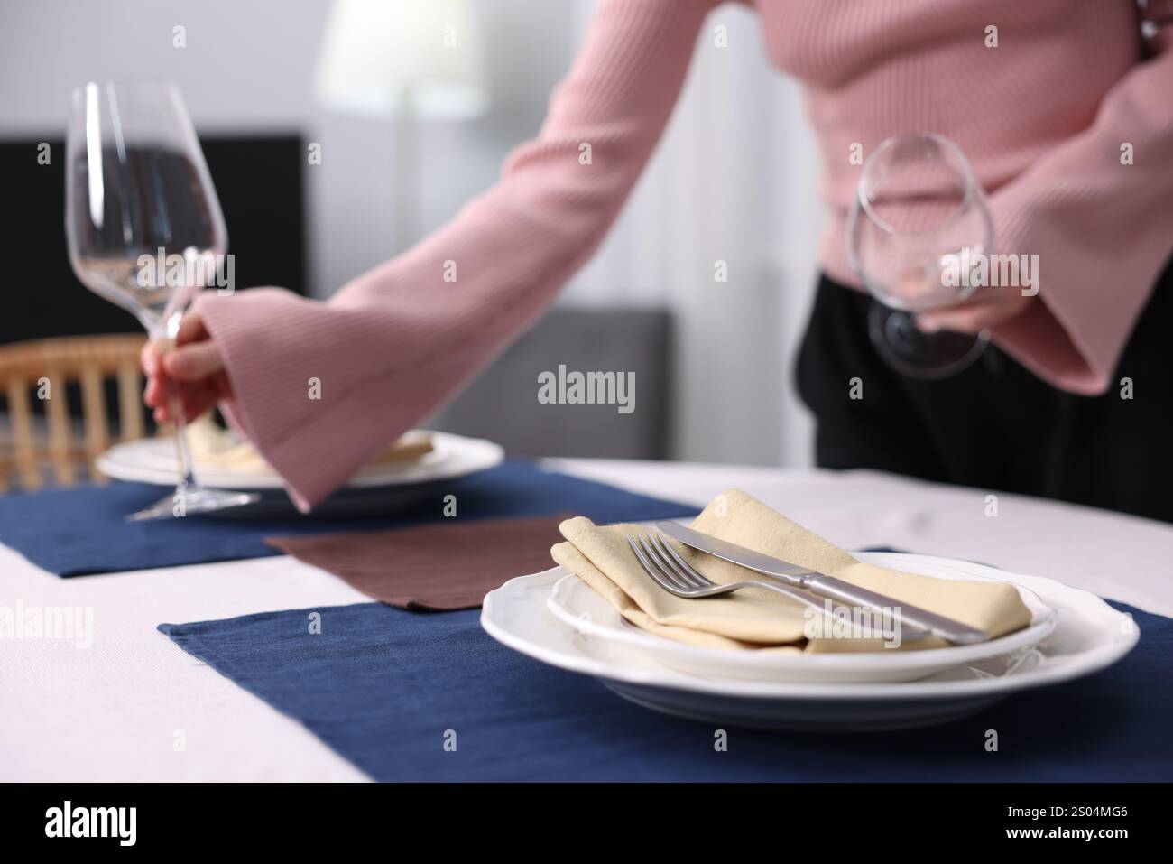Woman setting table for dinner at home, closeup Stock Photo - Alamy