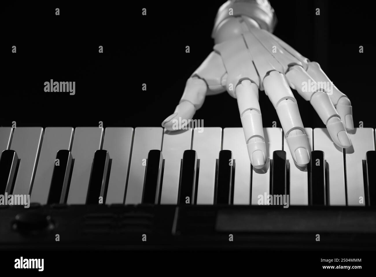 Artificial intelligence. Robot hand playing synthesizer on black ...