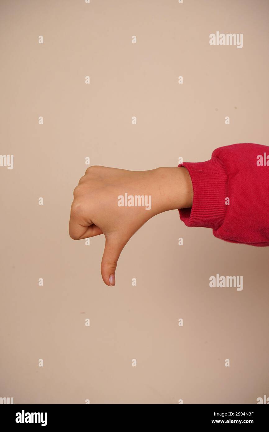 Dislike hand gesture depicted. One hand shows thumbs down on a light ...