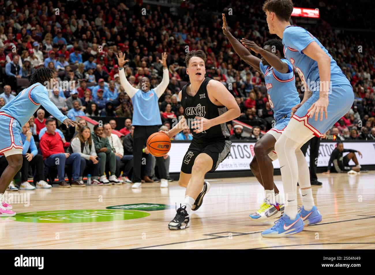 Cincinnati guard Simas Lukosius (41) dribbles against Dayton guard ...