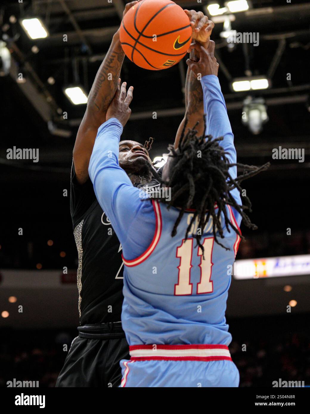 Cincinnati guard Jizzle James (2) blocks a shot by Dayton guard Malachi ...
