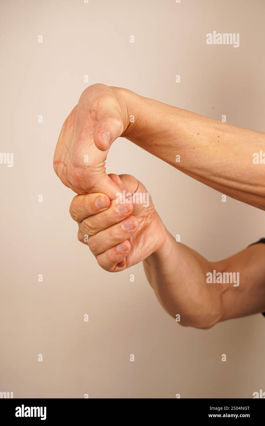 A close-up of hands performing a stretching exercise. One hand pulls ...