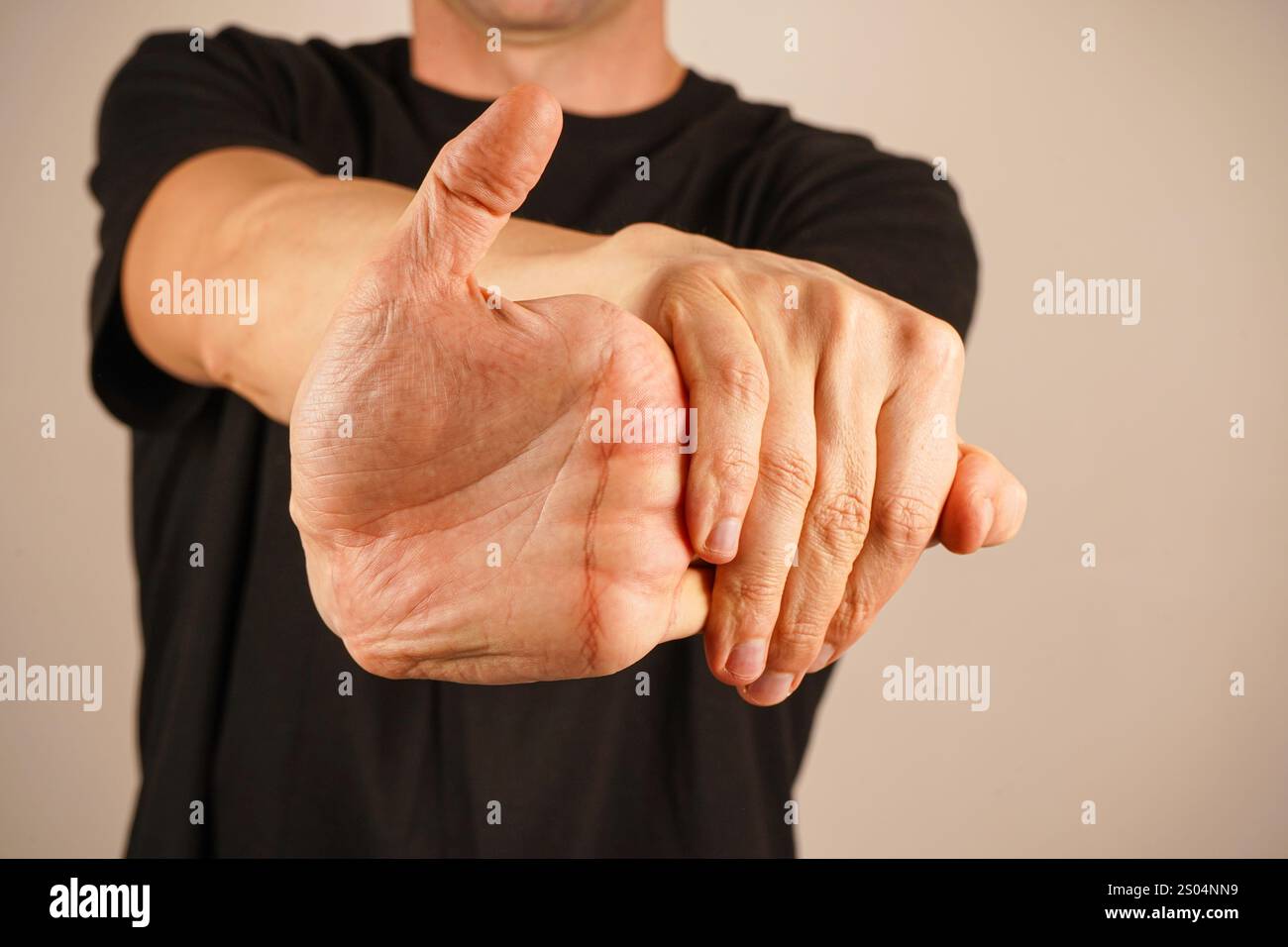 A close-up of hands performing a stretching exercise. One hand pulls ...