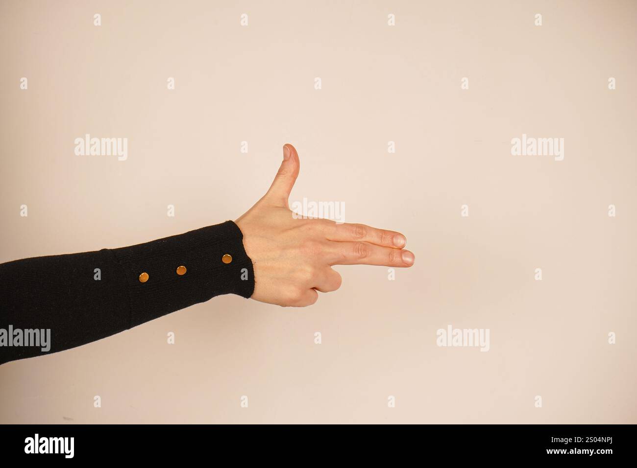 Fingers are arranged to mimic the shape of a gun, creating a playful ...