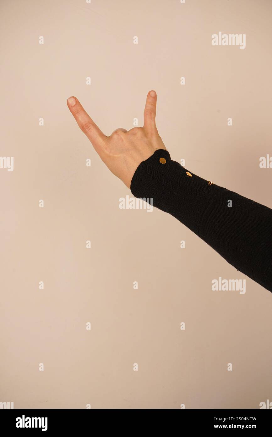 The hand raised in the classic rock and roll gesture symbolizes ...