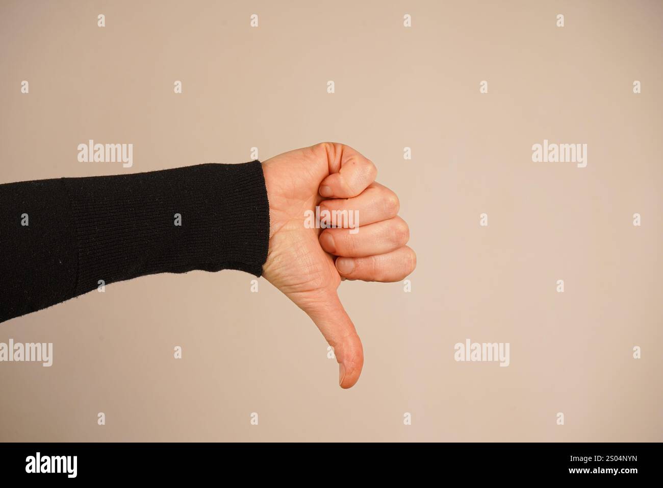 A hand showing a thumbs down, signaling disapproval or rejection. This ...