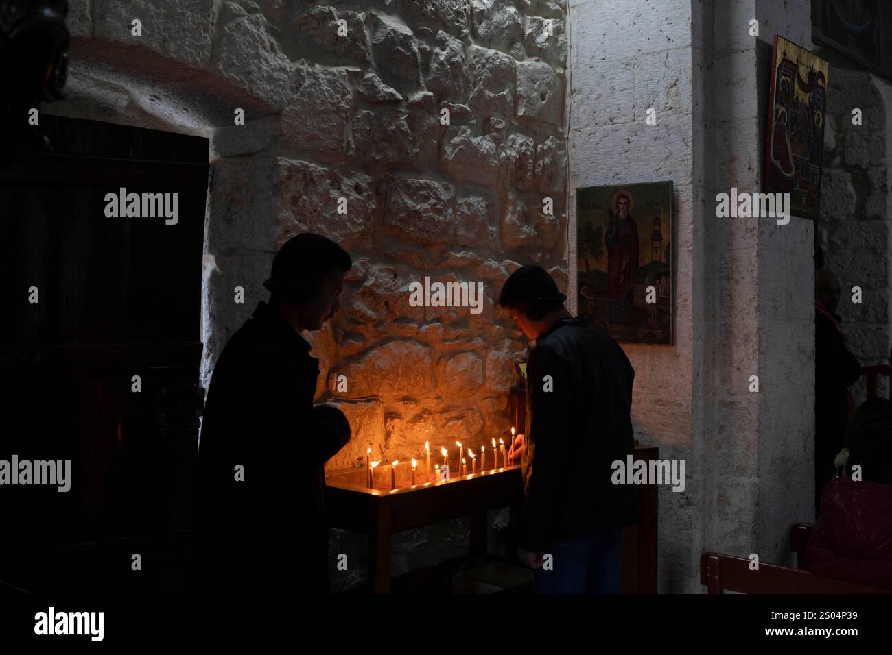 Christians light candles before the Christmas mass in the Greek ...