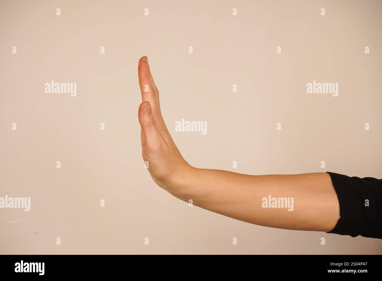 With the palm open and facing outward, the hand gestures a stop or ...