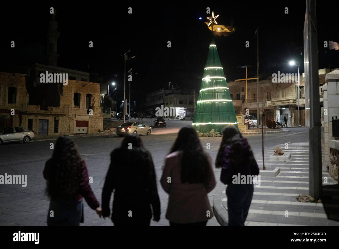 People walks past a Christmas tree after attending a Christmas mass at ...