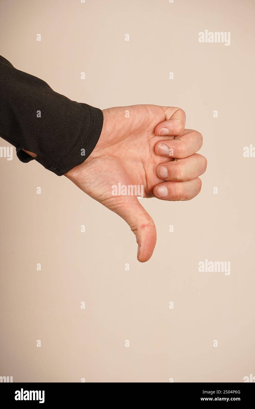 A hand showing a thumbs down, signaling disapproval or rejection. This ...