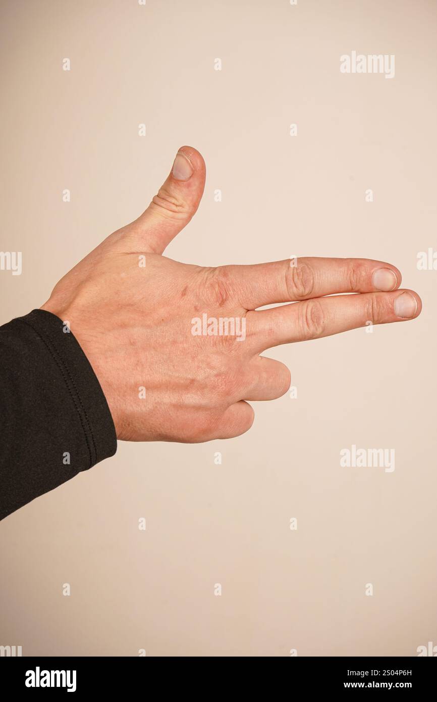The hand forms a pistol-like shape with extended fingers, symbolizing ...
