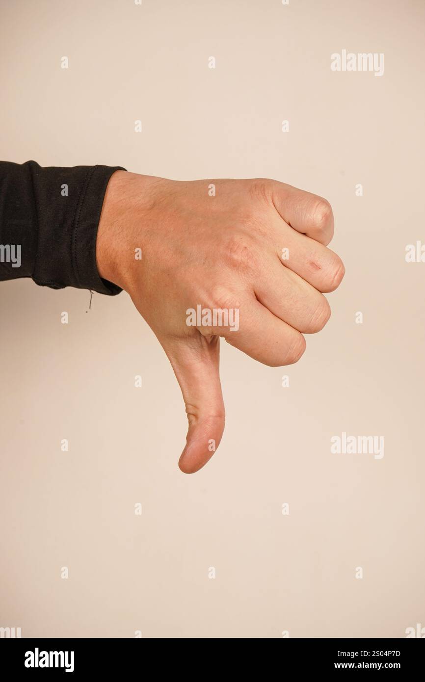 A hand showing a thumbs down, signaling disapproval or rejection. This ...