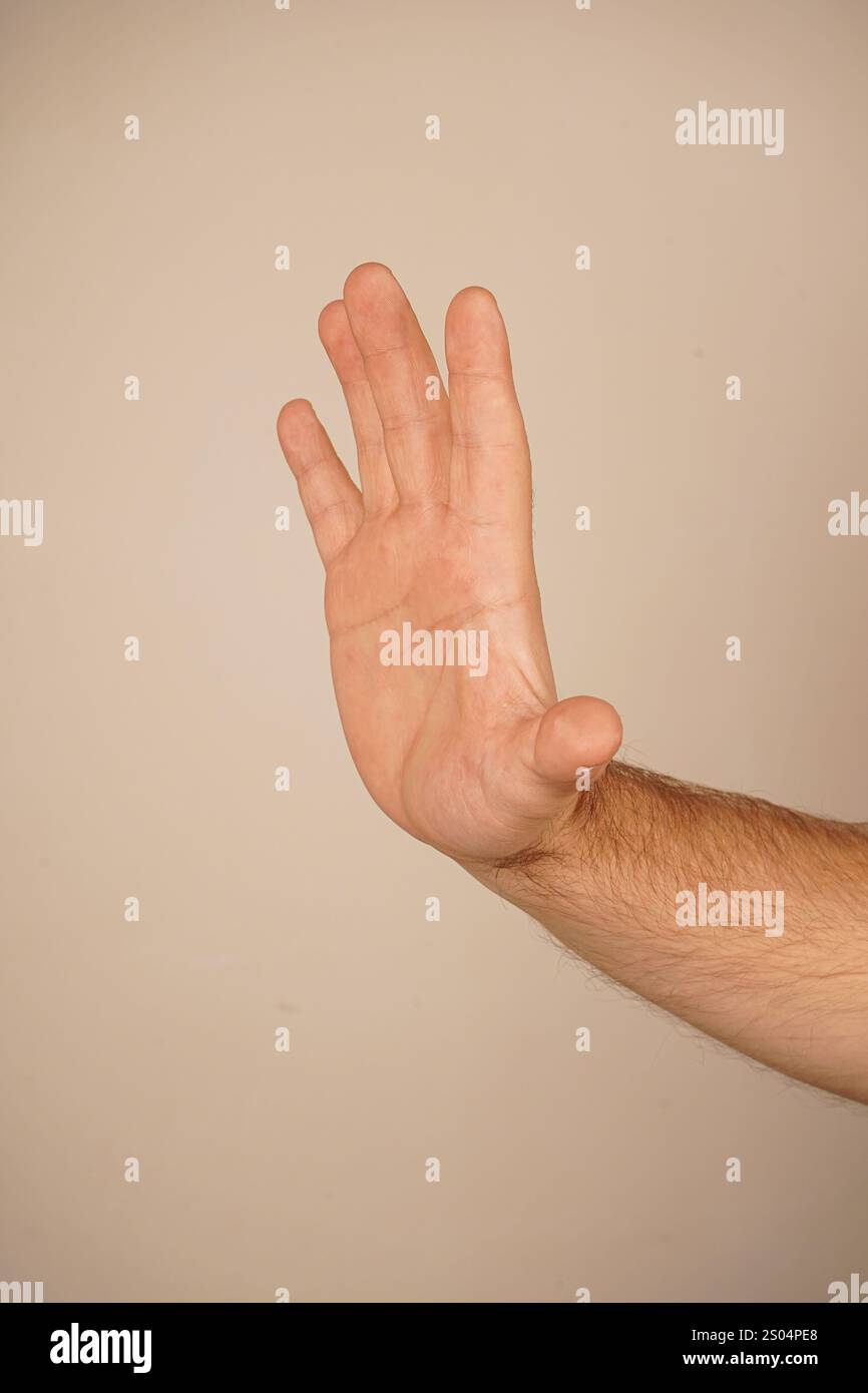 With the palm open and facing outward, the hand gestures a stop or ...