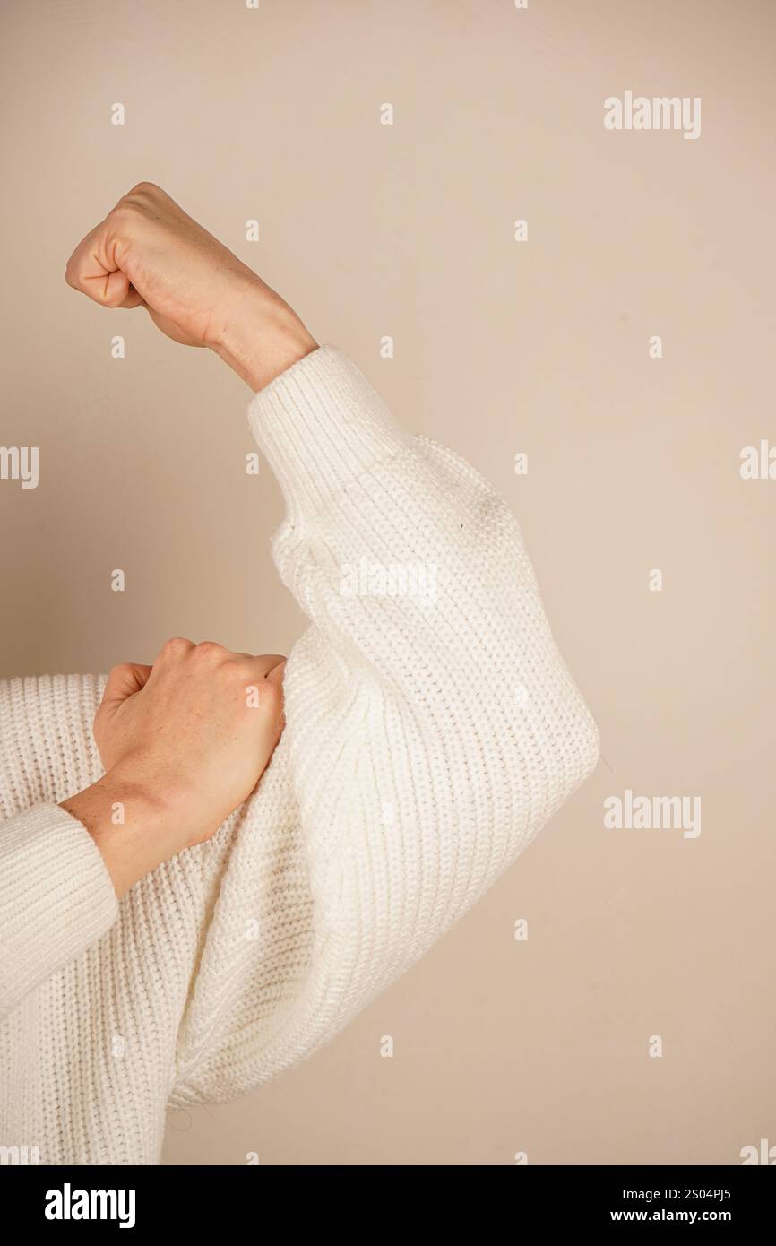 A hand clenched into a fist with the arm bent at the elbow highlights ...