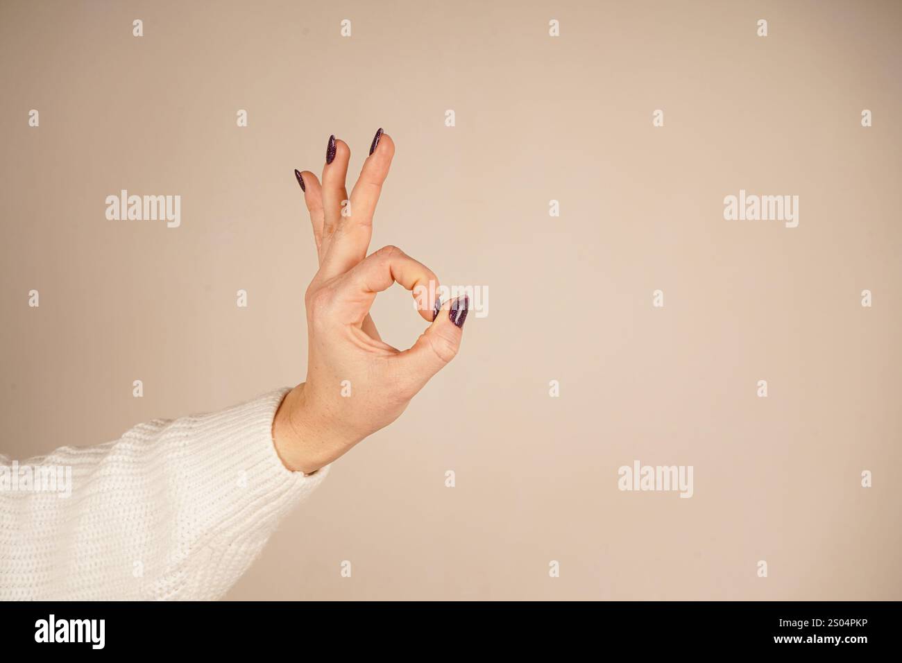 The thumb and index finger form a loop, with the other fingers raised ...