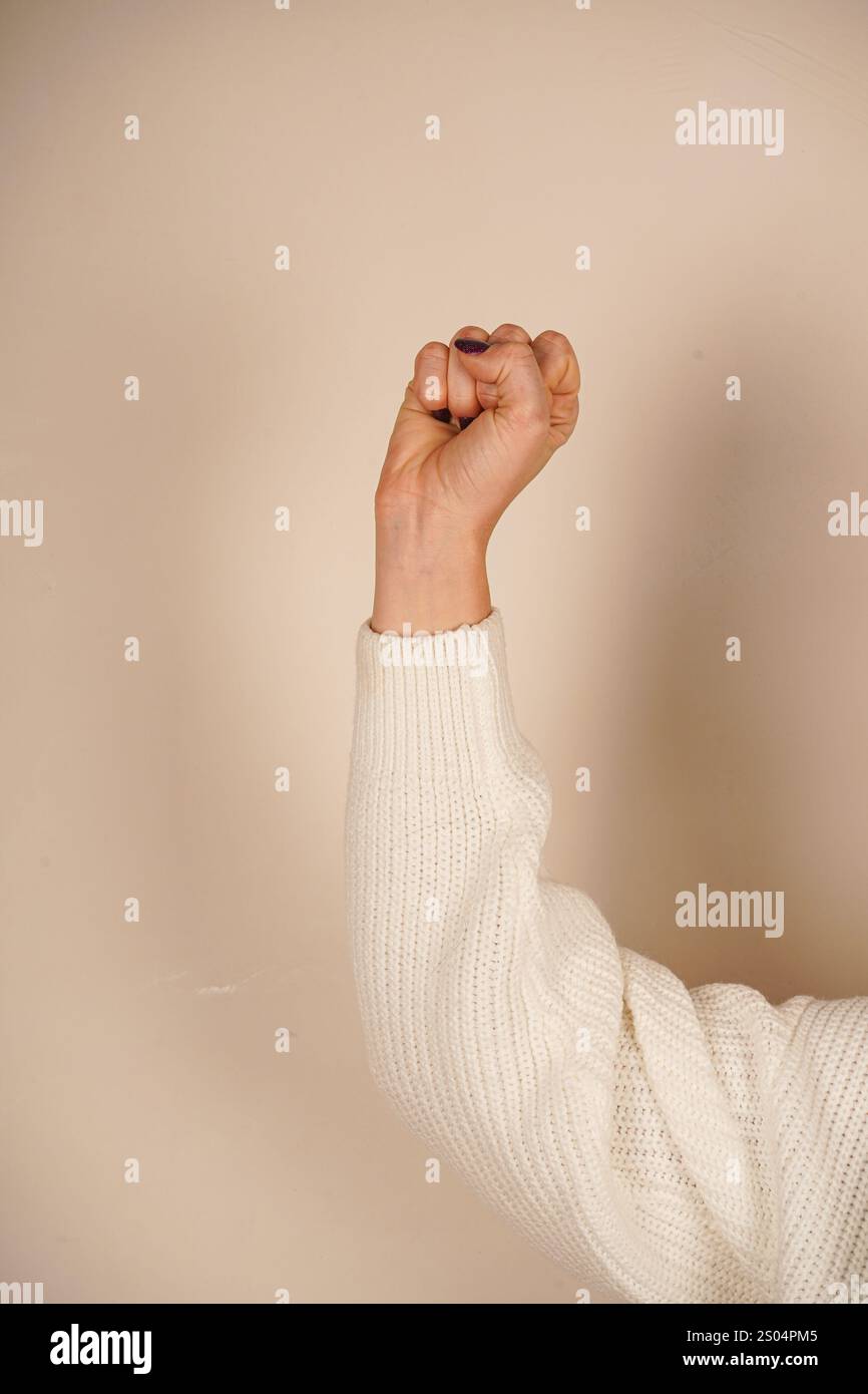 A hand clenched into a fist with the arm bent at the elbow highlights ...