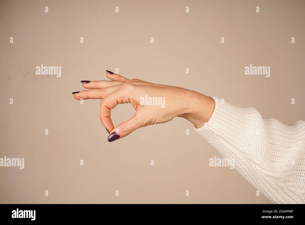The thumb and index finger form a loop, with the other fingers raised ...