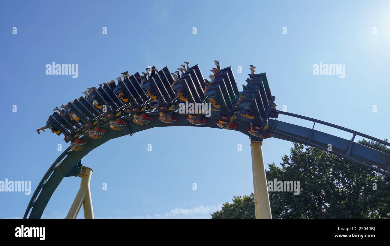 People ride through an inversion on the intense inverted roller coaster ...