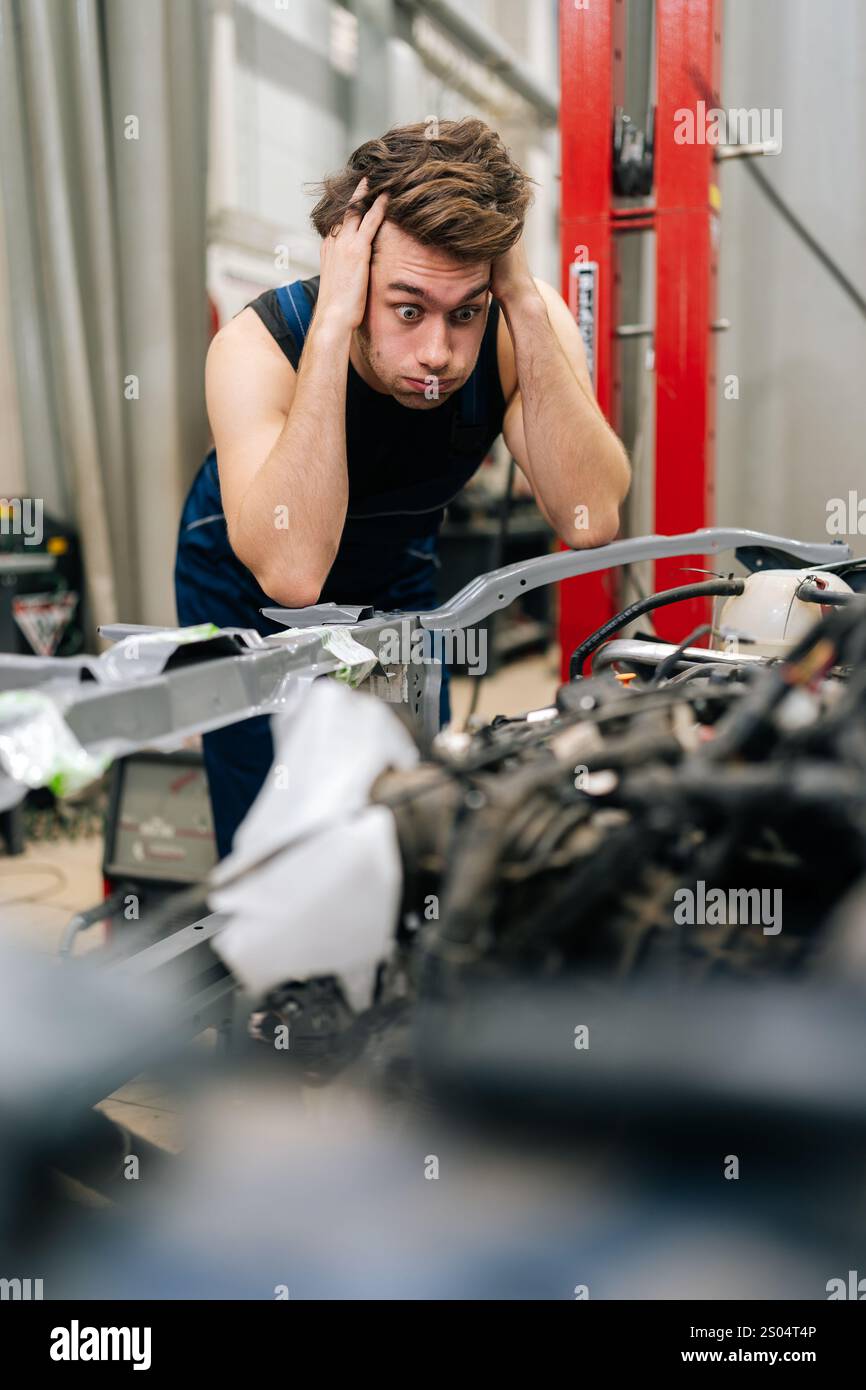 Vertical portrait of mechanic having stressful day at car repair shop ...