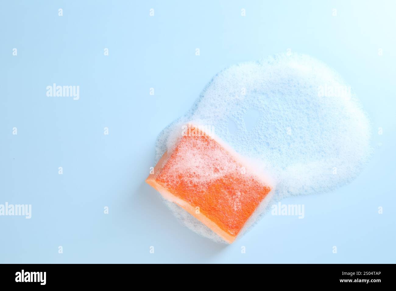One sponge with foam on light blue background, top view. Space for text ...