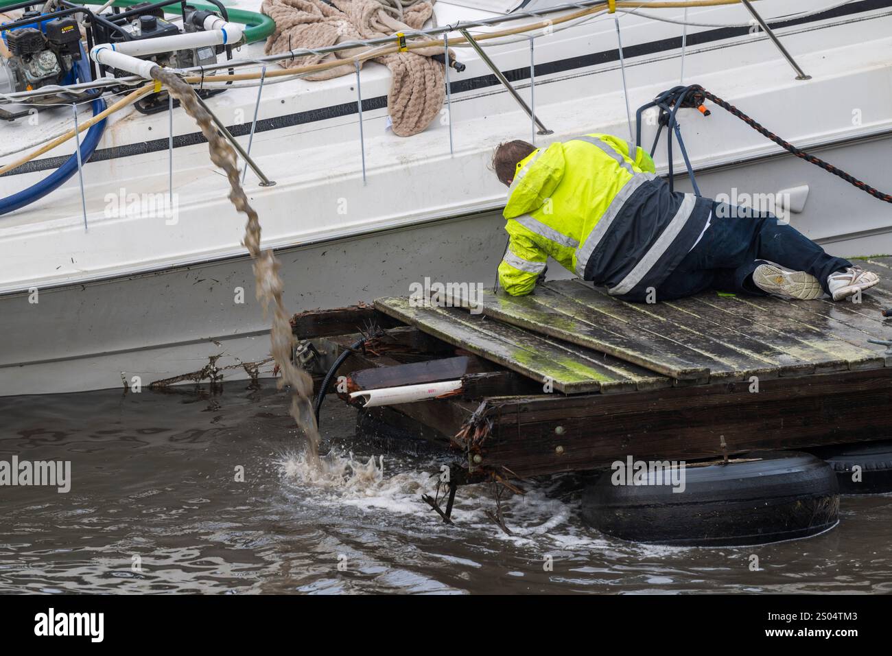 A man repairs a boat, which partially sunk in Santa Cruz Harbor in ...