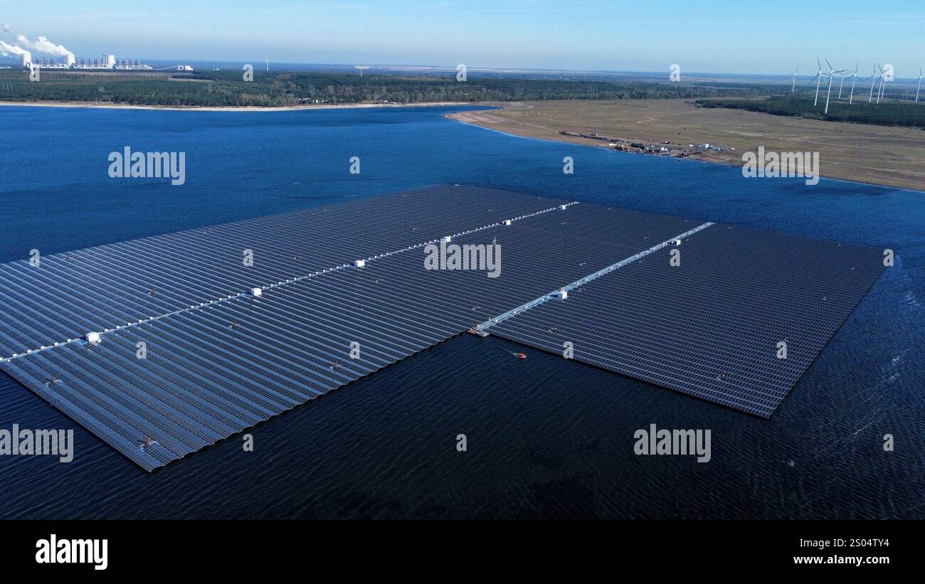A floating solar farm operates near wind turbines, back right, on the ...