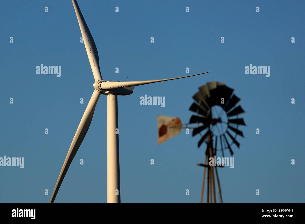 A wind turbine stands in contrast to an old windmill at the Smoky Hills ...