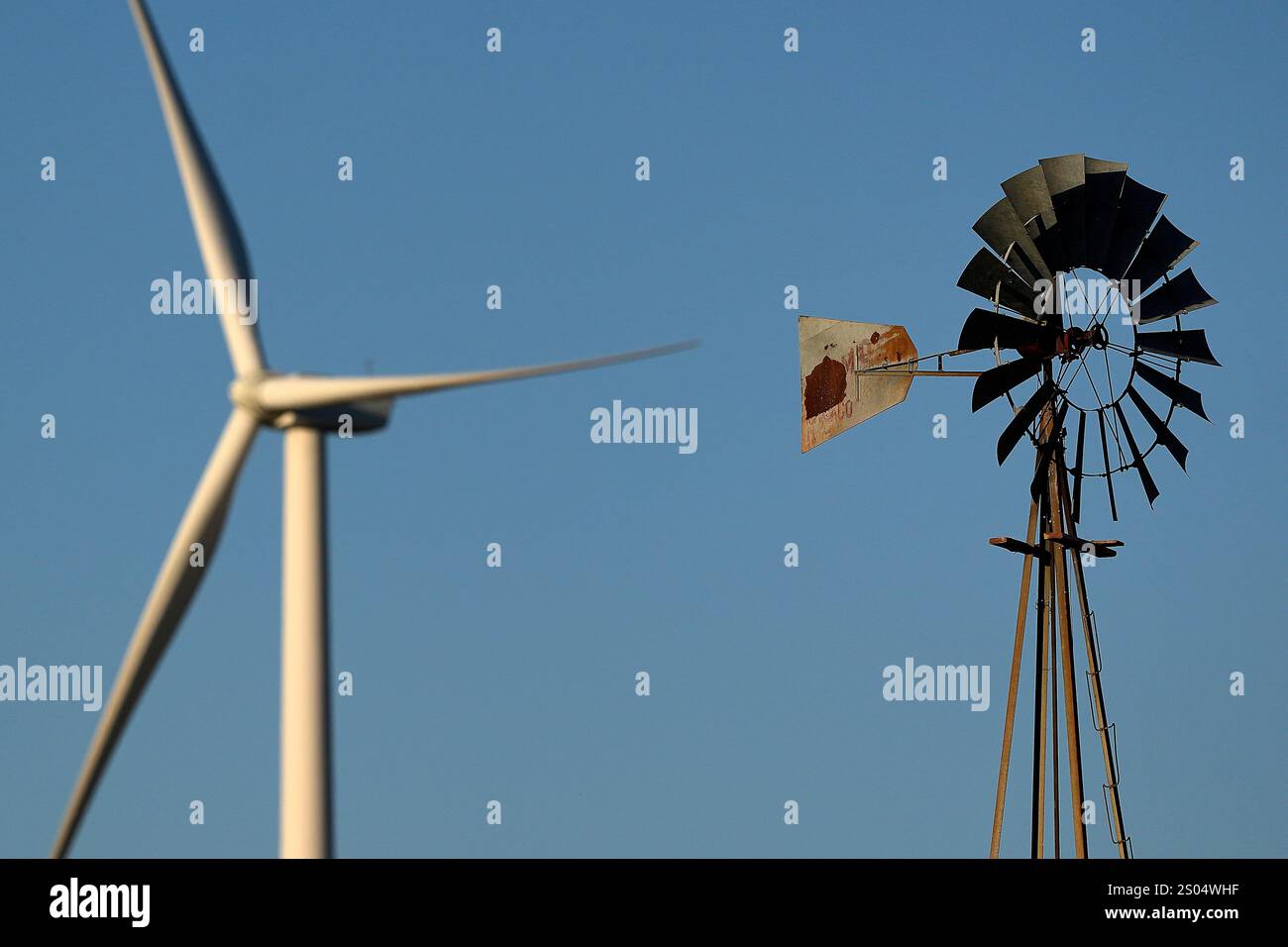 A wind turbine stands in contrast to an old windmill at the Smoky Hills ...