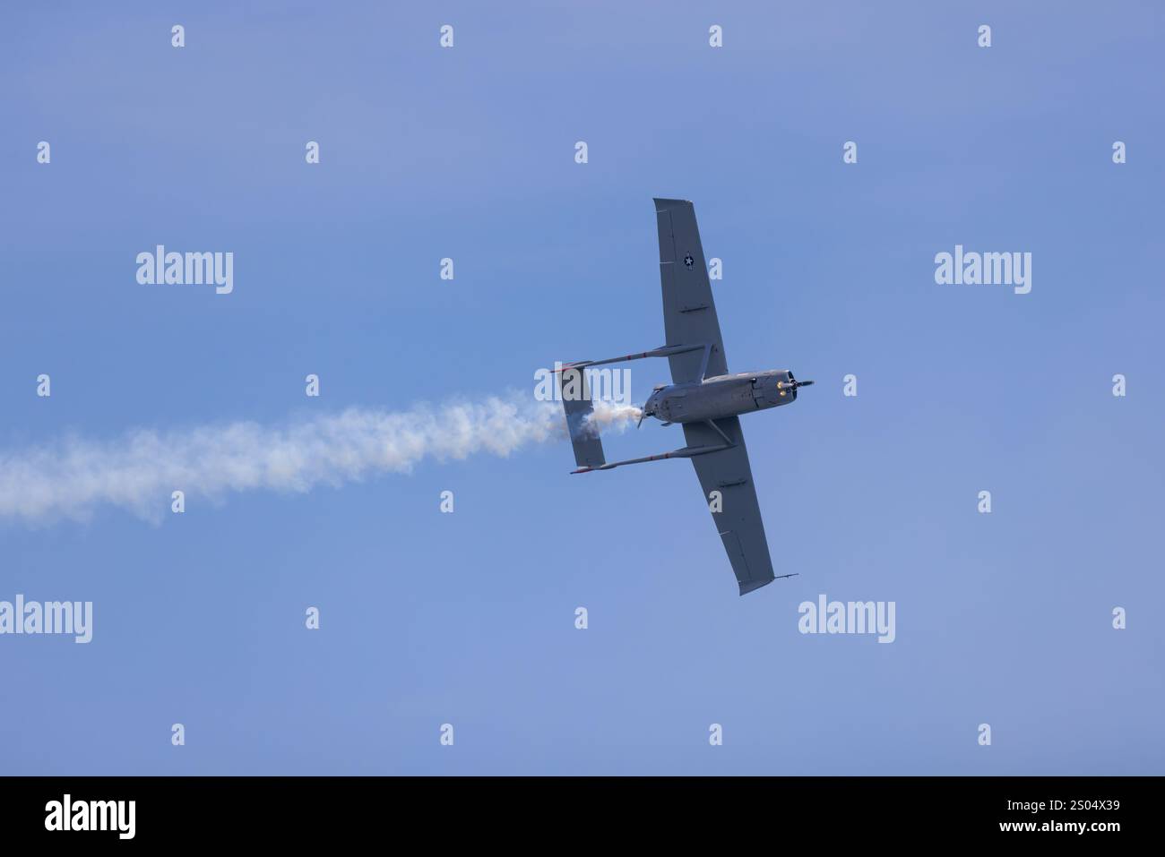 An aircraft executes an aerobatic maneuver, trailing smoke during the ...