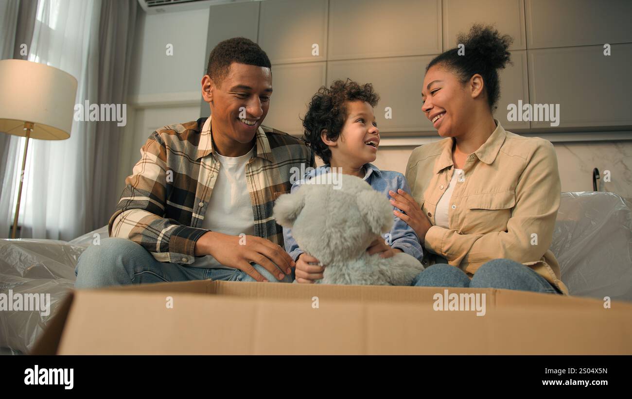 Happy little boy son kid open box unpacking parcel take teddy bear ...
