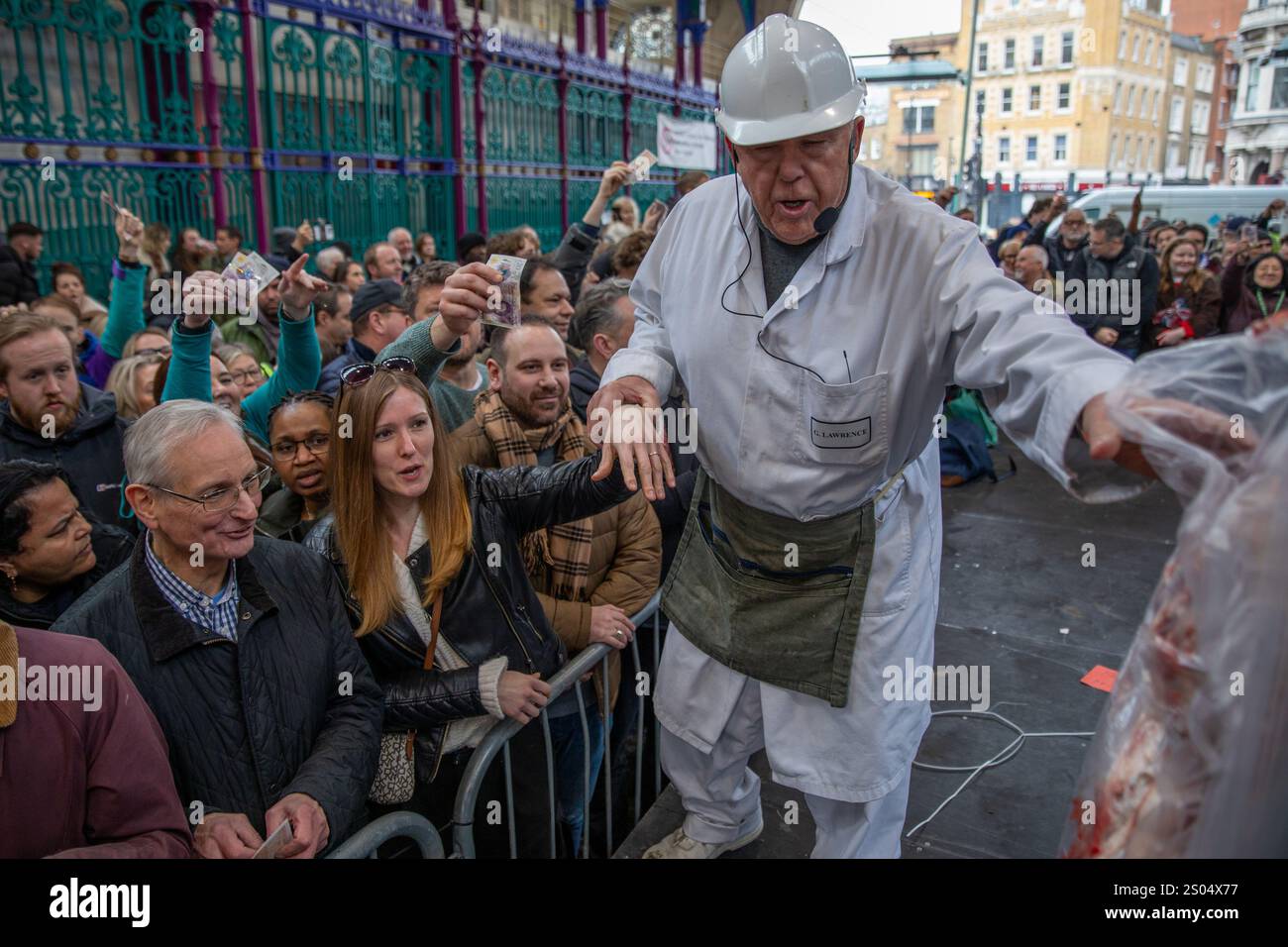 A butcher holds a Ladies hand to pass her a joint of meat. In a ...