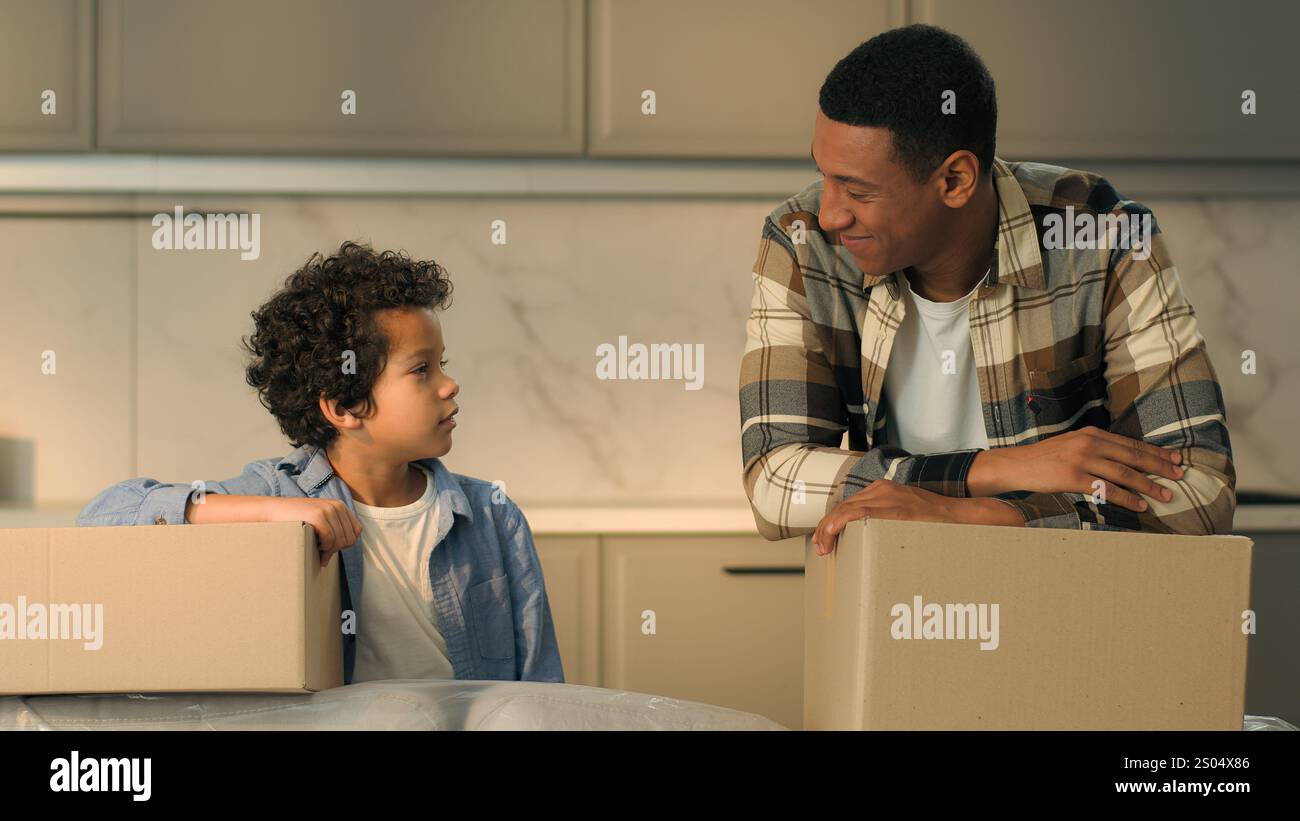 Happy family African American dad son moving in new house cardboard ...