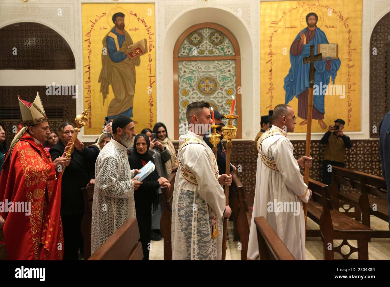 Iraqi Christians attend a Christmas Eve mass at the Sacred Heart Church ...
