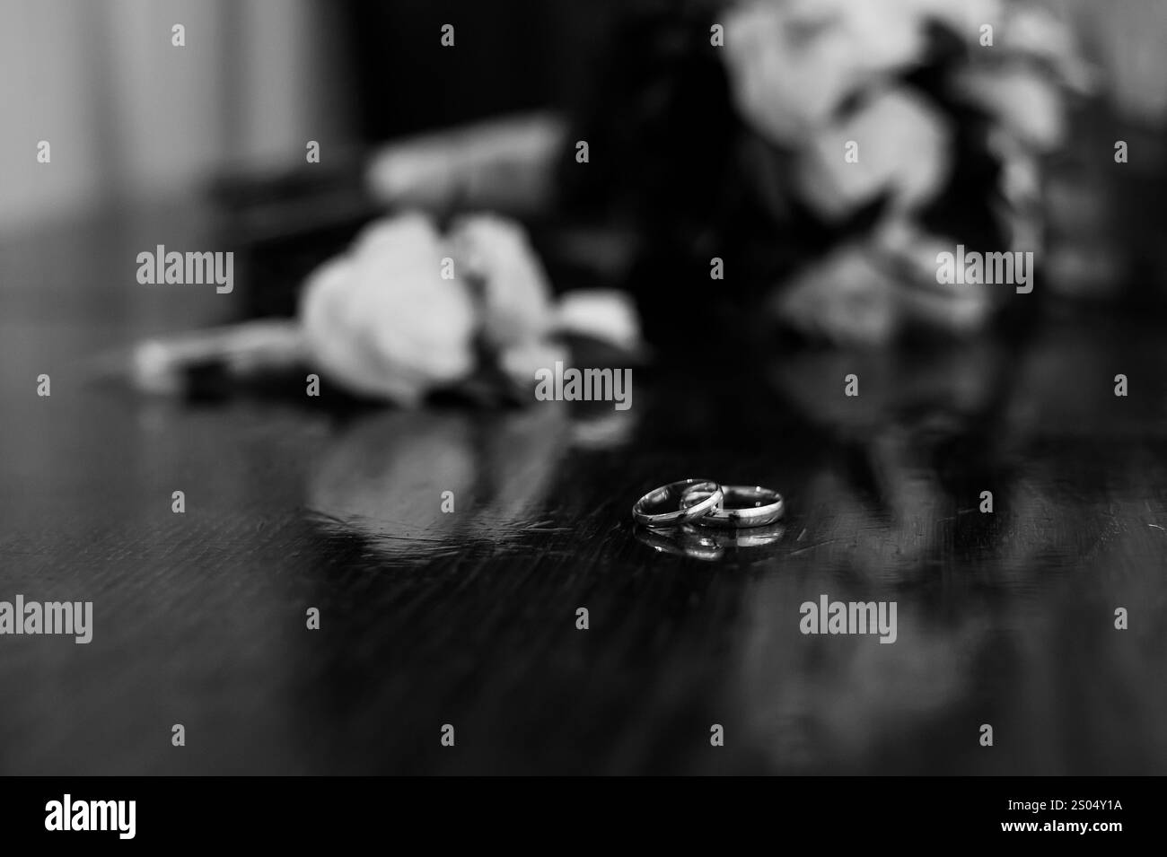 Elegant Wedding Rings on a Reflective Surface Surrounded by Flowers ...