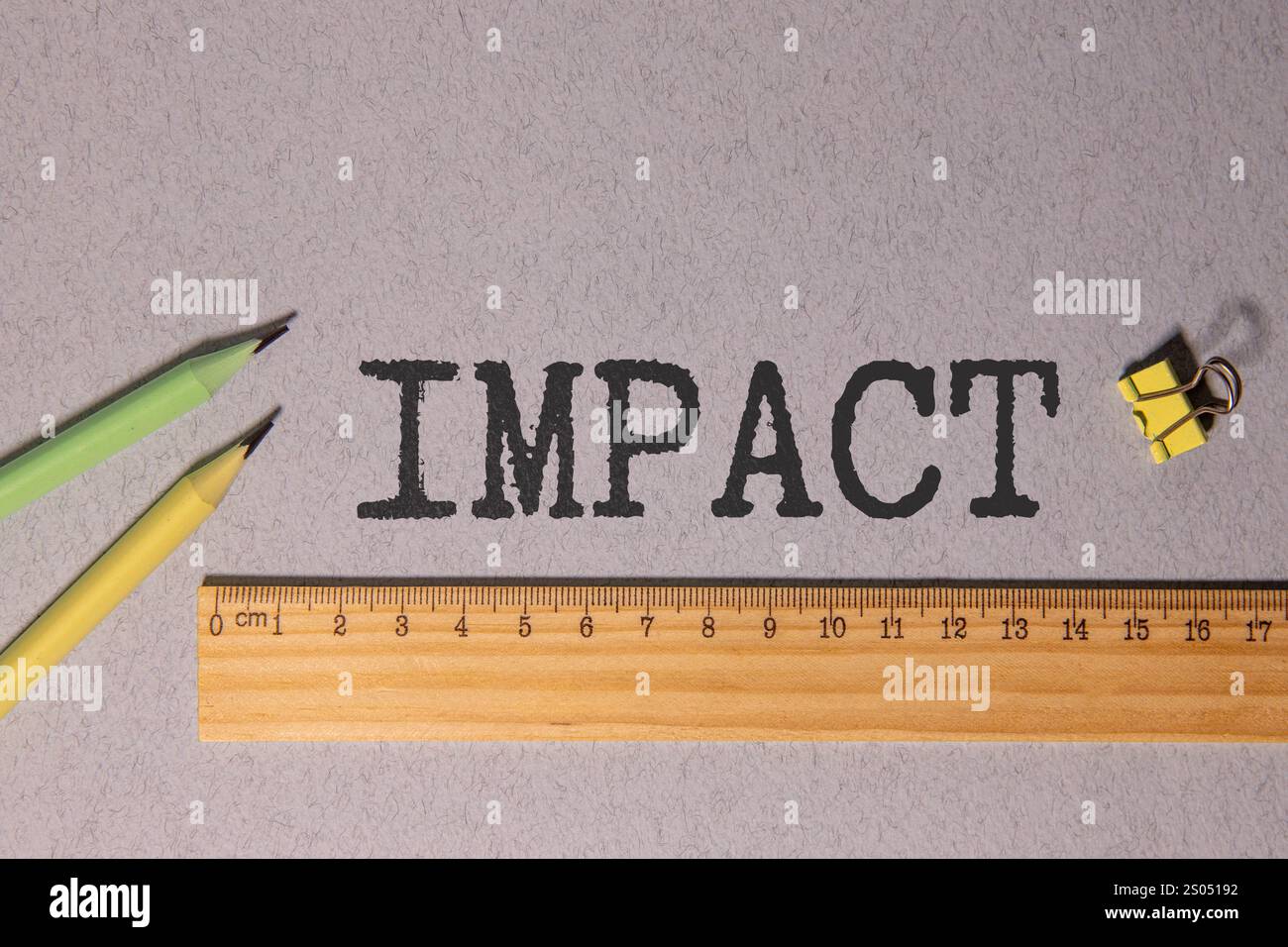 Impact word written on ripped torn yellow paper with blue background ...