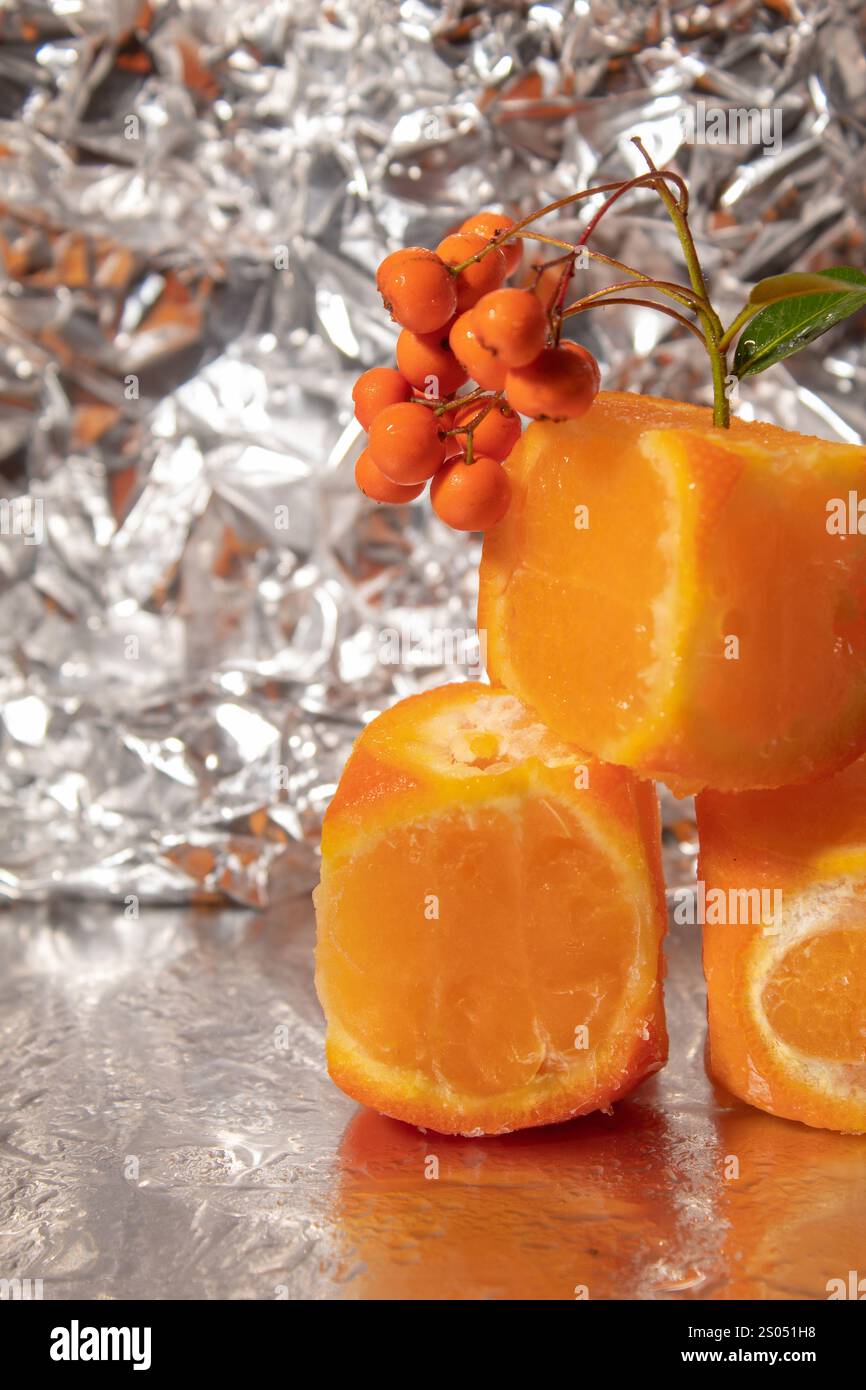 Cubes from iced tangerine on crumpled aluminium foil close-up Stock ...