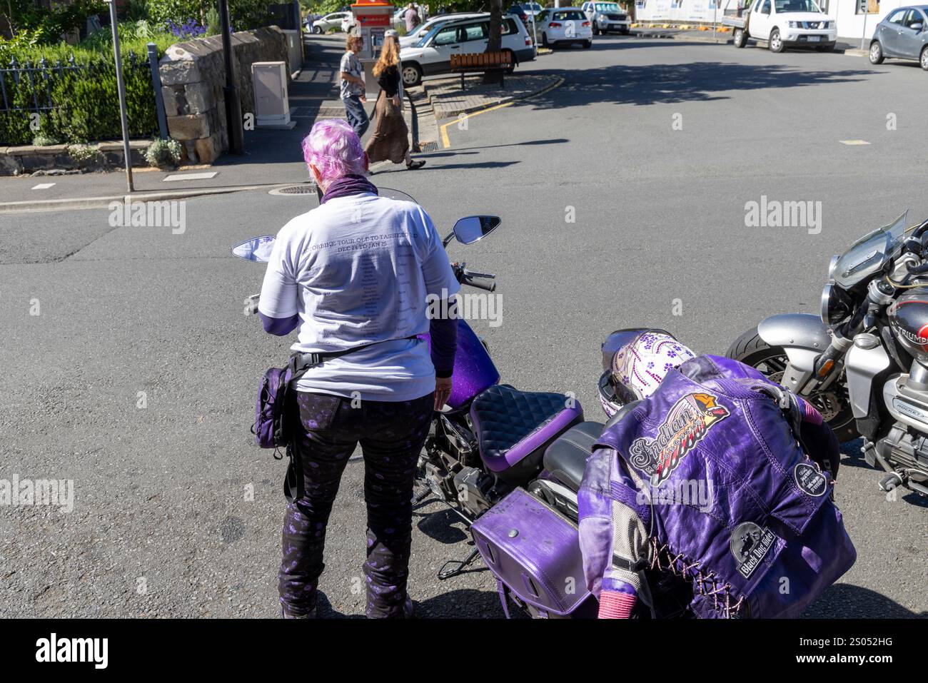 Female biker with purple hair, purple jacket and purple motorbike on a ...